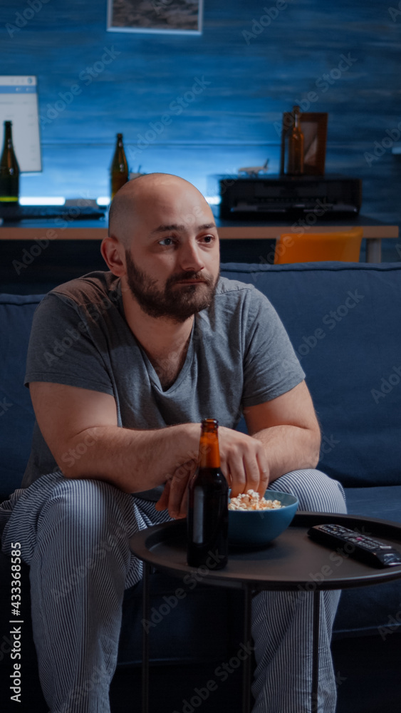 Scared shocked astonished man looking at horror movie at tv, eating ...