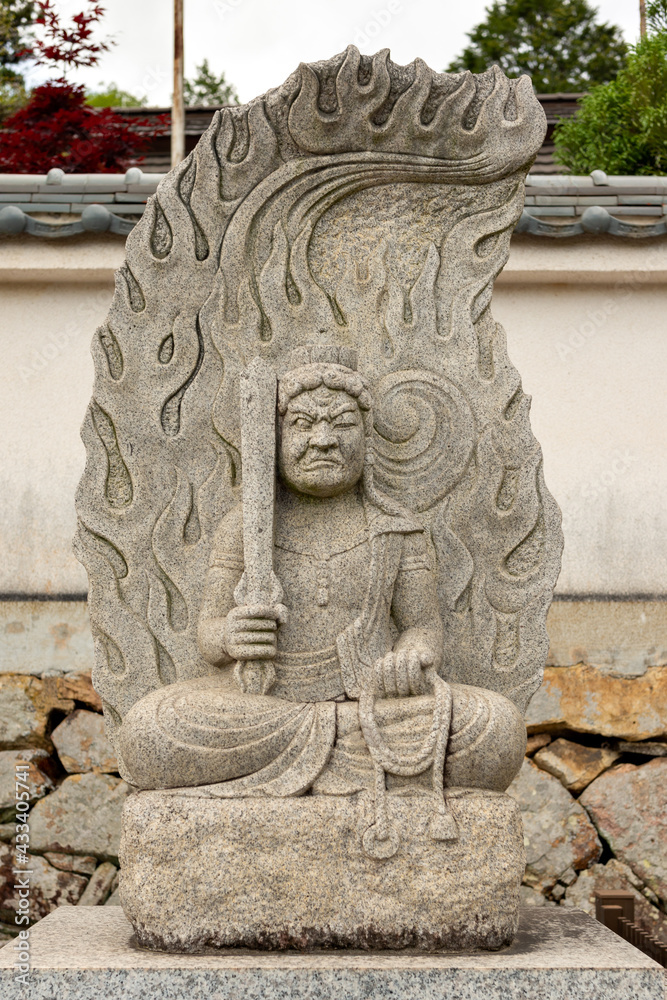 Stone statue of Fudo Myoo (God of fire) at Taifuku-ji temple in Kobe ...
