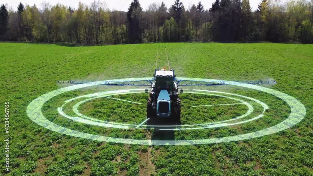 Aerial view of autonomous self-driving tractor with autopilot spraying ...