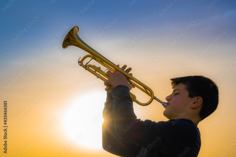 Teen boy playing trumpet against a beautiful sunset sky Stock Photo ...