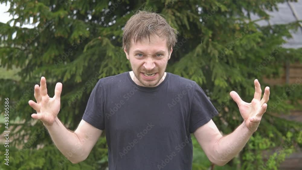 Portrait of angry young man in rain looking furious, aggressive and ...