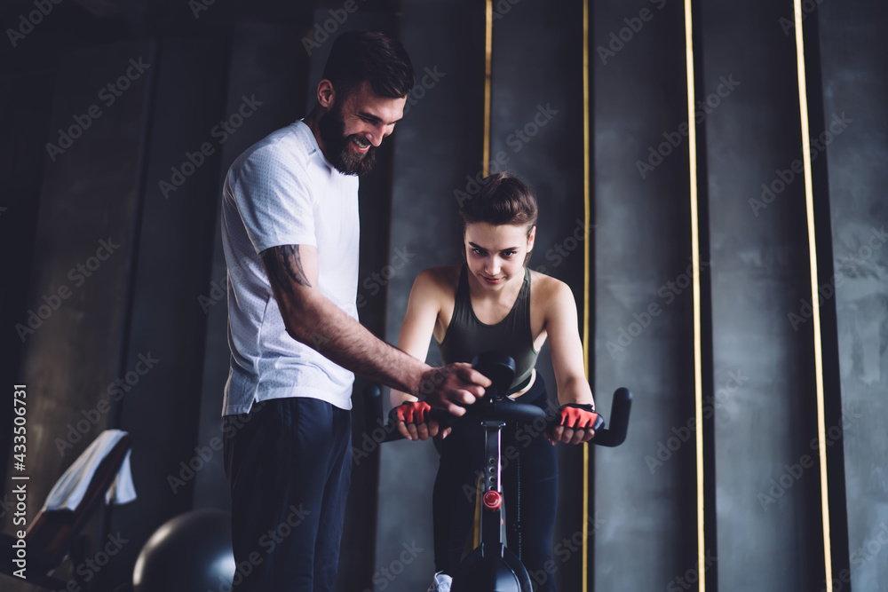 Cheerful caucasian male trainer satisfied with her clent fitness ...