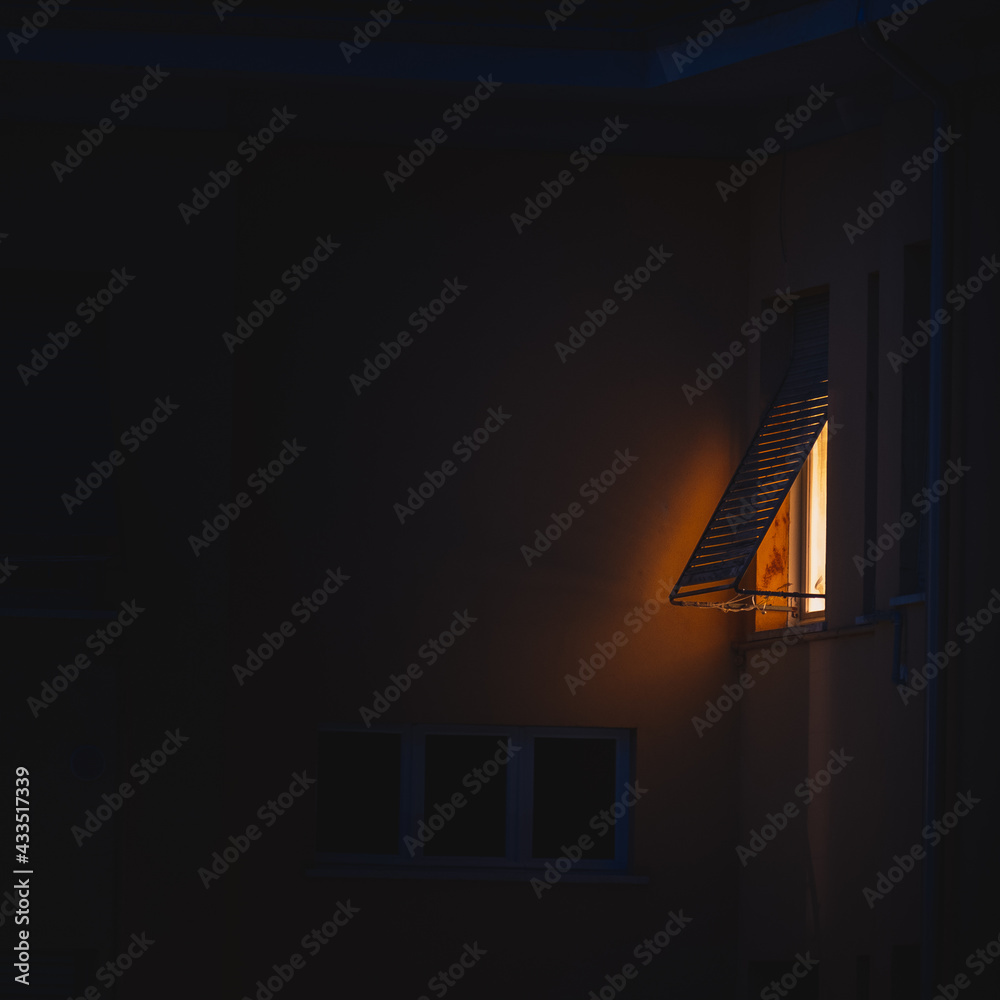 Light coming out of the window of an apartment building at night Stock ...