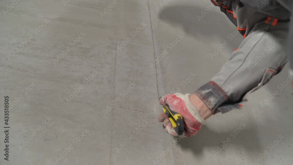 A worker cuts the plaster on the wall with a knife. Wall repair. The ...