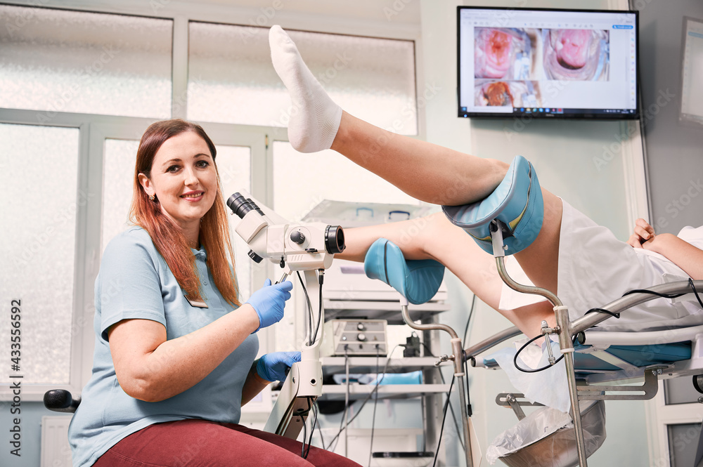 Portrait of gynecologist while examining patient with colposcope. Woman ...
