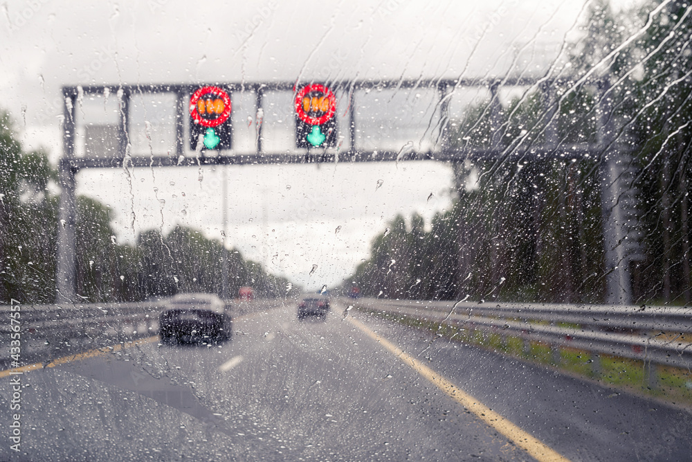Road view with speed limit signs through windshield car window with ...