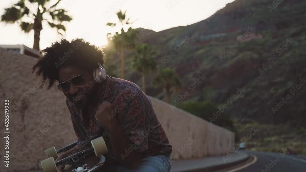 Happy Afro man having fun dancing while listening to music with ...