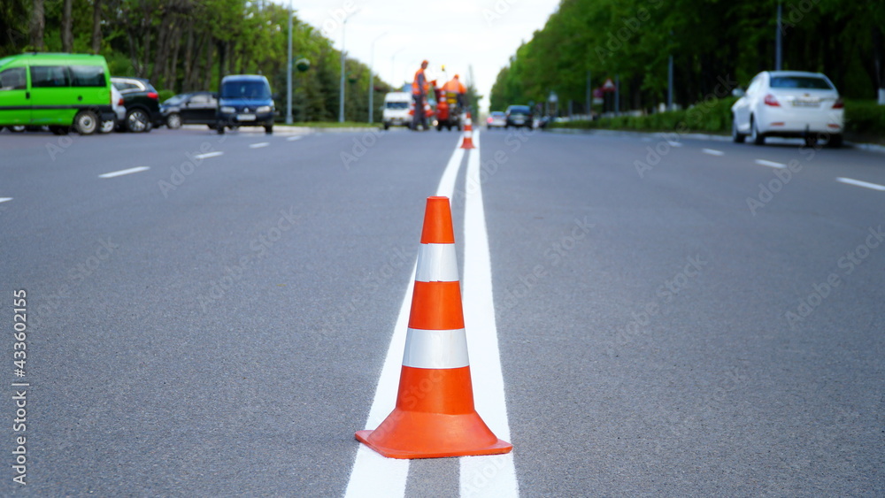 Macro shot of road traffic cones with orange and white stripes standing ...