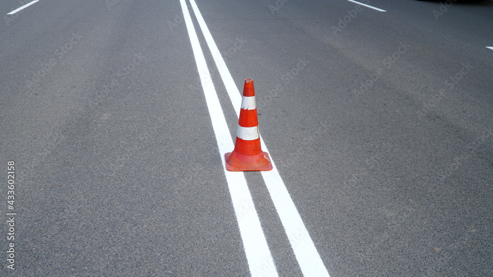 Macro shot of road traffic cones with orange and white stripes standing ...