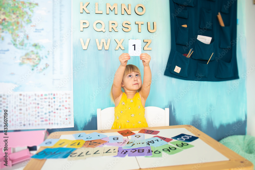 Little caucasian girl studying numbers and math in the classroom ...