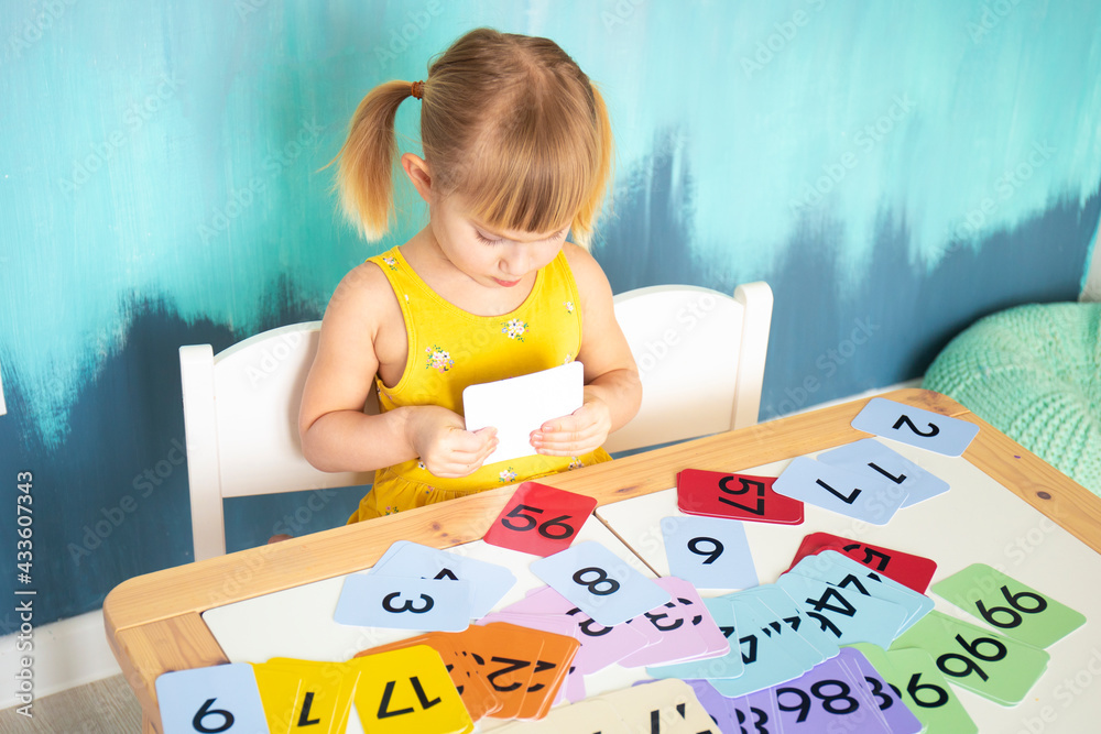 Little caucasian girl studying numbers and math in the classroom ...