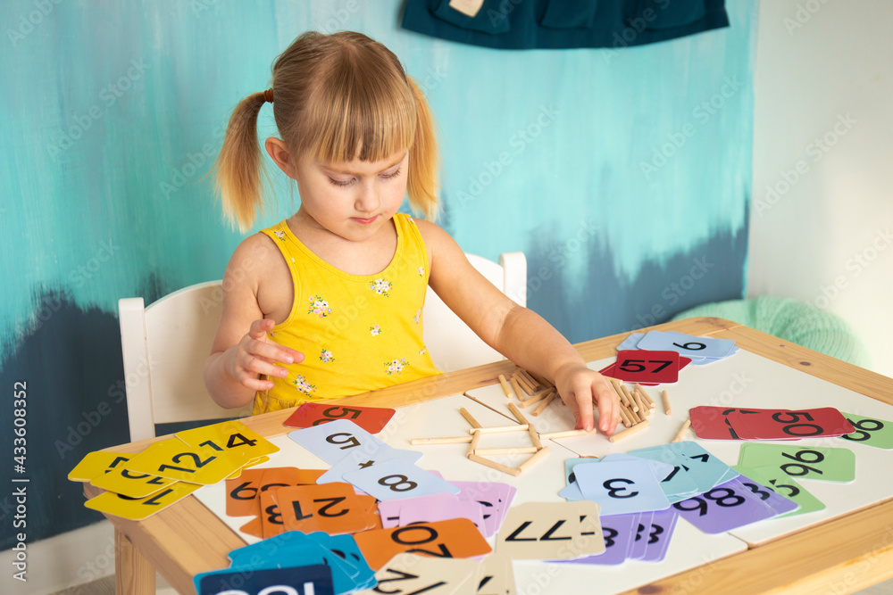 Little caucasian girl studying numbers and math in the classroom ...
