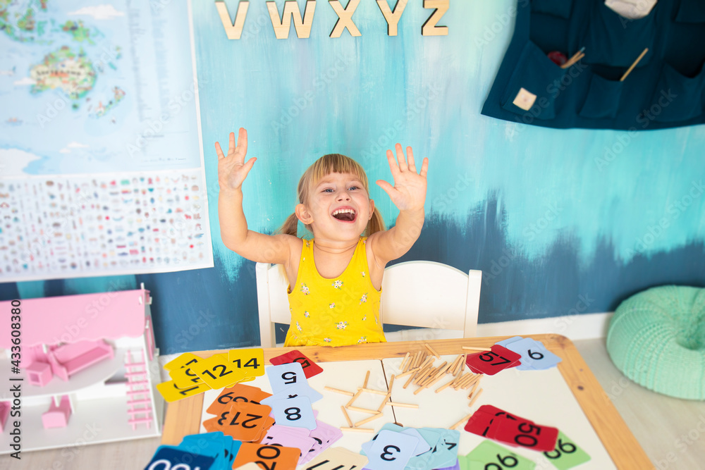 Little caucasian girl studying numbers and math in the classroom ...
