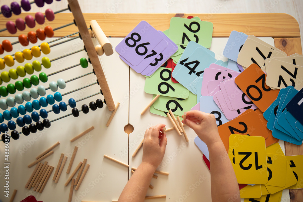 Little caucasian girl studying numbers and math in the classroom ...