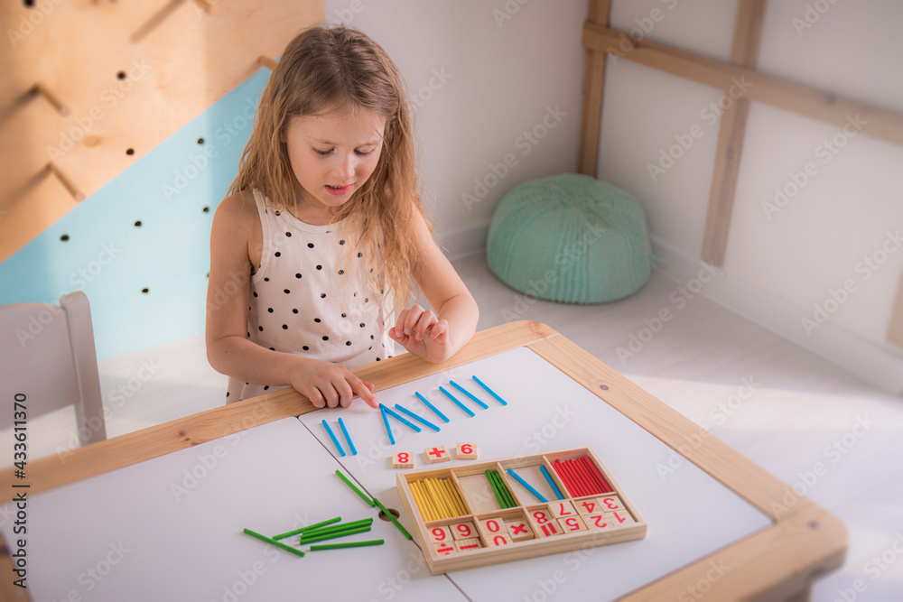 Caucasian girl learning to count at home in the classroom, preschool ...