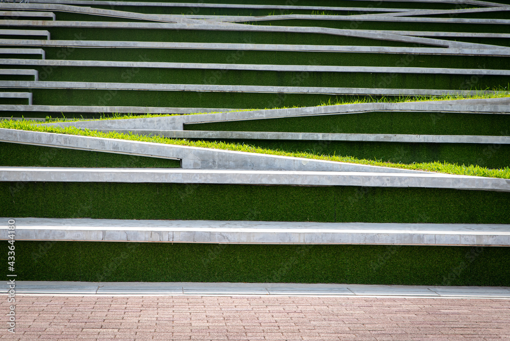 Abstract concrete walkway is descending in steps. Downstairs is a brick ...