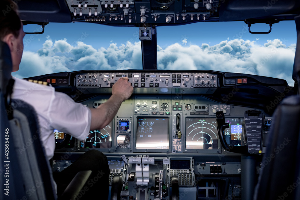 Rear view of caucasian male pilot sitting in aircraft cockpit and ...