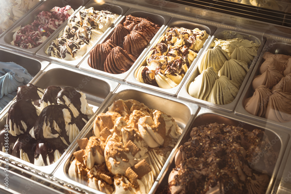 Selection of two rows of ice cream of different flavours in stainless ...