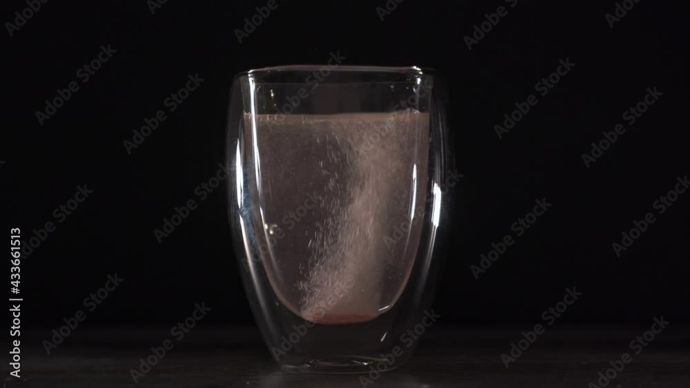 a transparent glass with a double bottom filled with water drops a ...