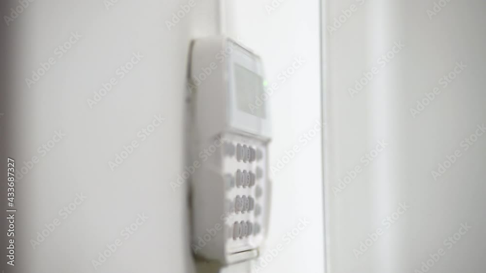 Hand entering alarm system password of an apartment, home or business ...