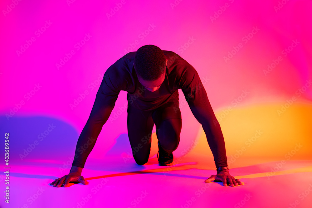 Full length concentrated fit African American male runner standing in ...