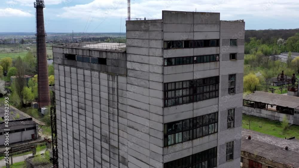 Tall old factory building on green nature background. Abandoned ...