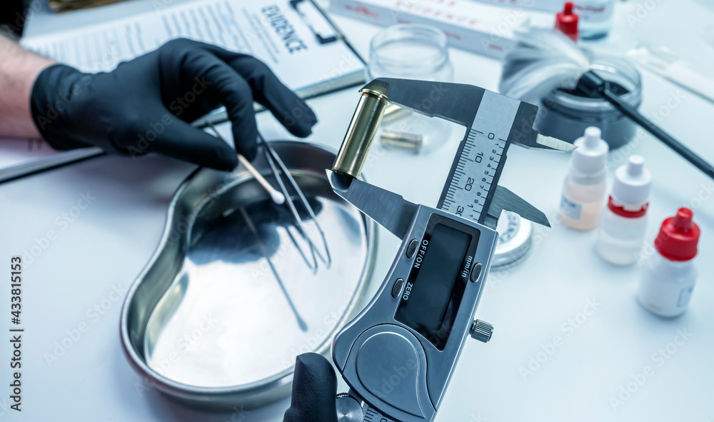 Scientific police examining a bullet cap in ballistic Laboratory ...