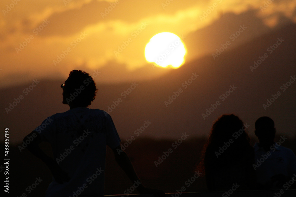 Silueta de personas a contraluz disfrutando de un atardecer en Panamá ...