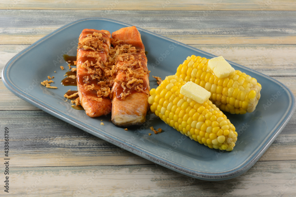 Baked salmon fish fillets with BBQ sauce and crispy onions as topping ...