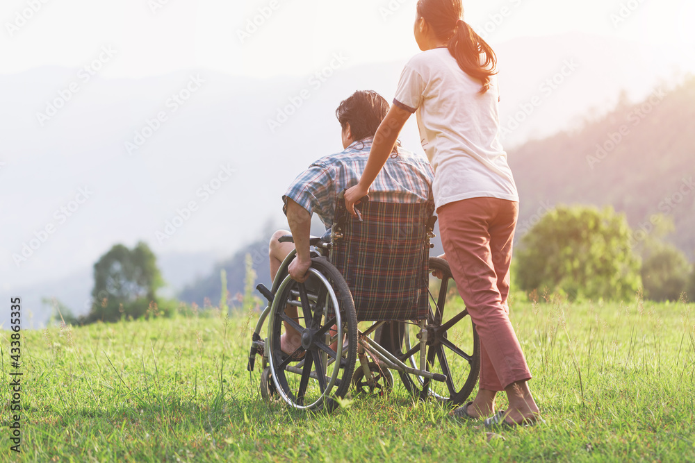 Disabled handicapped man in wheelchair and care helper walking on ...