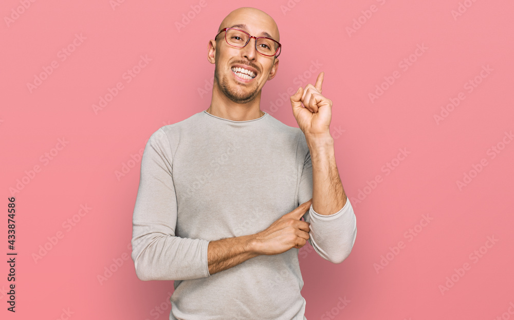 Bald man with beard wearing casual clothes and glasses with a big smile ...