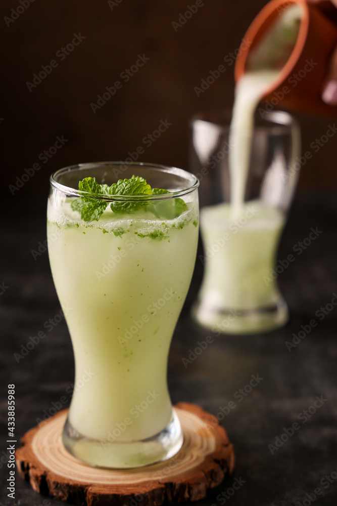 Pouring serving Spiced buttermilk , chaas , chaach , moru , sambharam ...