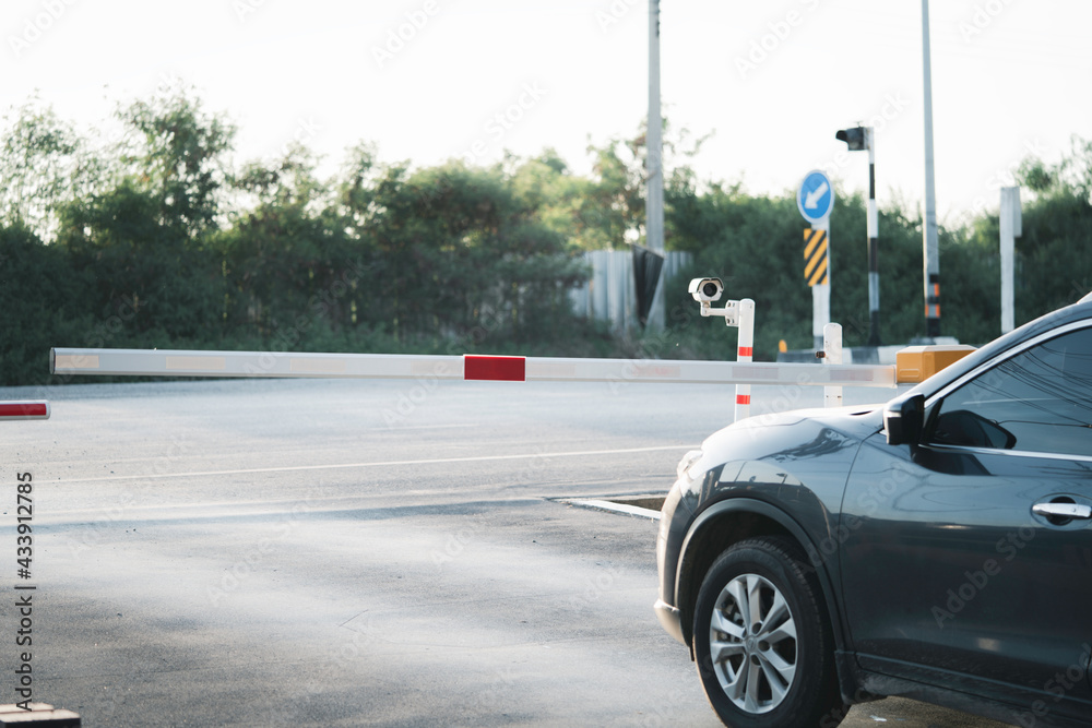Black car accessing to open gate and entrance and exit from village ...