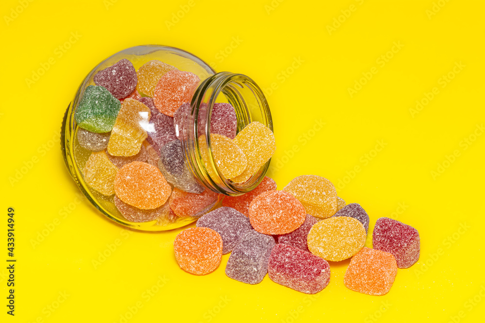 Candy Jar on bright yellow background, colorful soft jubes, sugary ...