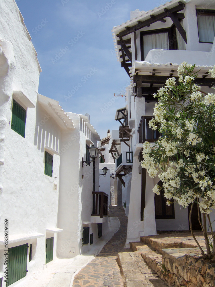 Typical Spanish construction of a narrow alley between white beach ...