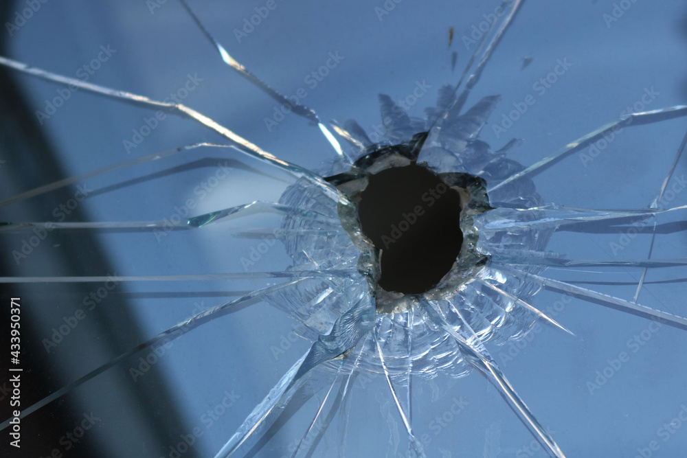 broken glass cracked with a hole from a stone or a bullet in the ...
