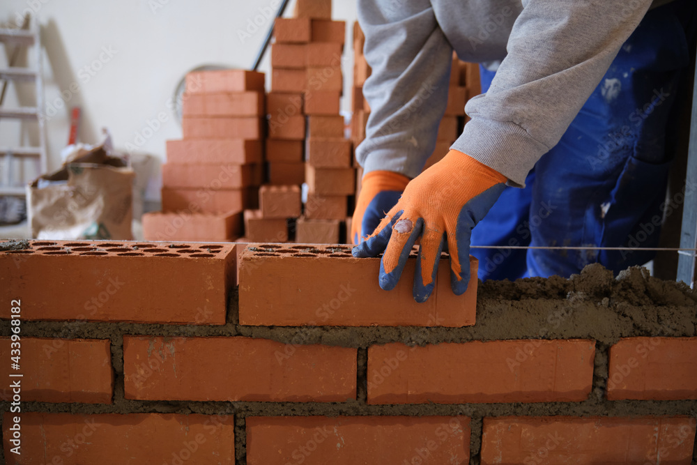 Construction worker building a brick wall. Man bricklaying. Mason ...