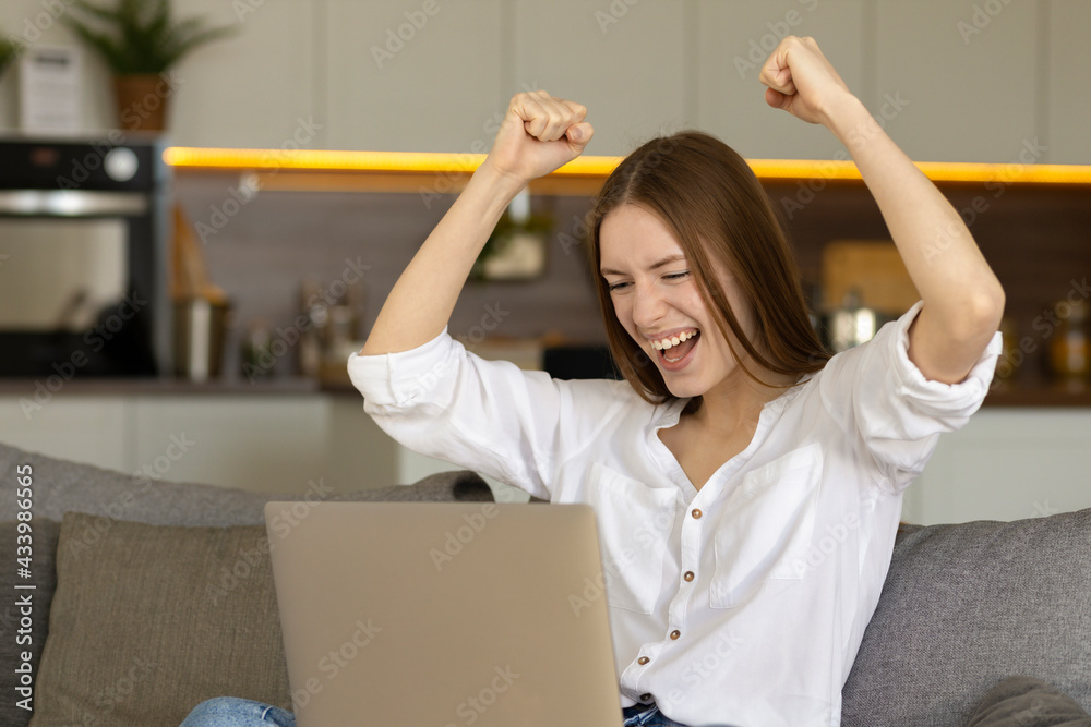 Excited happy caucasian woman sitting sitting on the couch at home feel ...