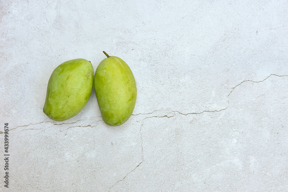 Green mango on grungy cement floor background, Group of fresh mangoes ...