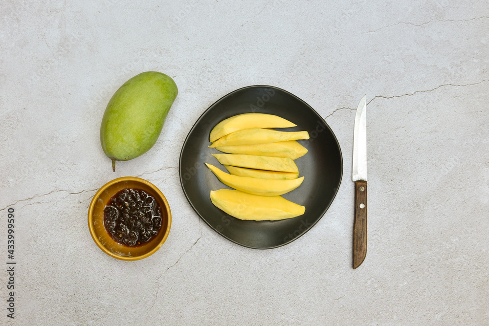 Green mango and ready to eat on black dish with sweet fish sauce on ...
