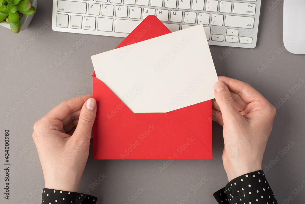 First person top view photo of female hands holding open red envelope ...