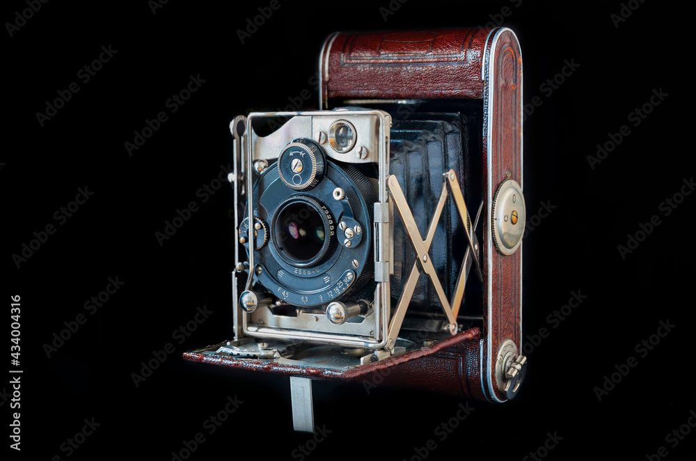Vintage folding camera isolated on the black background. Close shoot of ...