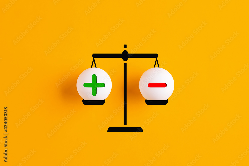 Plus and minus or positive and negative symbols are in balance on a ...