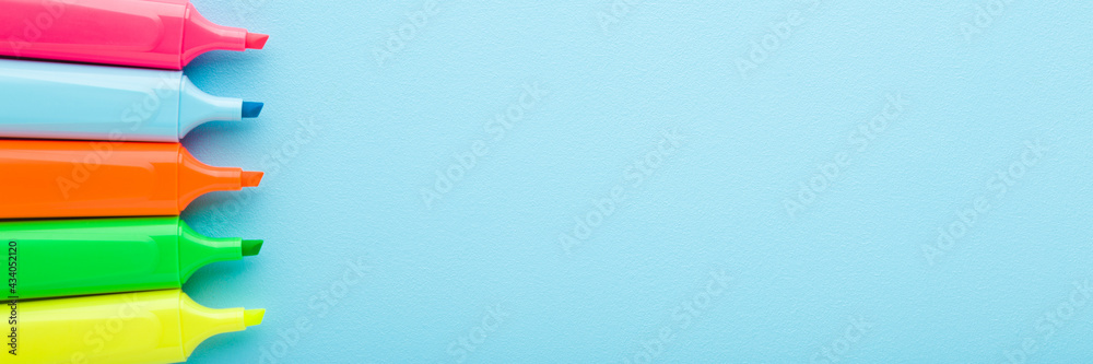 New colorful bright highlighters on light blue table background. Pastel ...