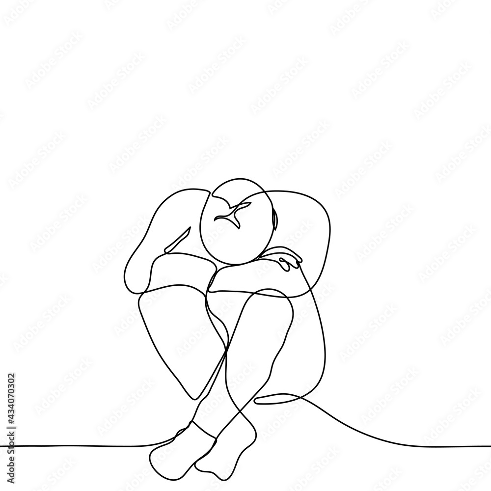 depressed man sits on the floor with his head resting on his forearms ...
