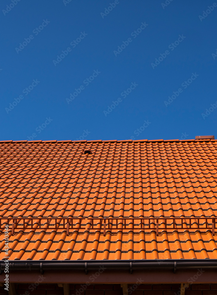 Red corrugated metal profile roof installed on a modern house. The roof ...