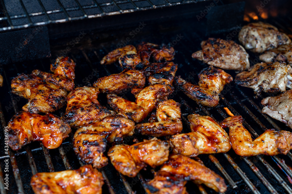 Bbq chicken wings on a barbecue grill cooking with a nice chargrilled ...