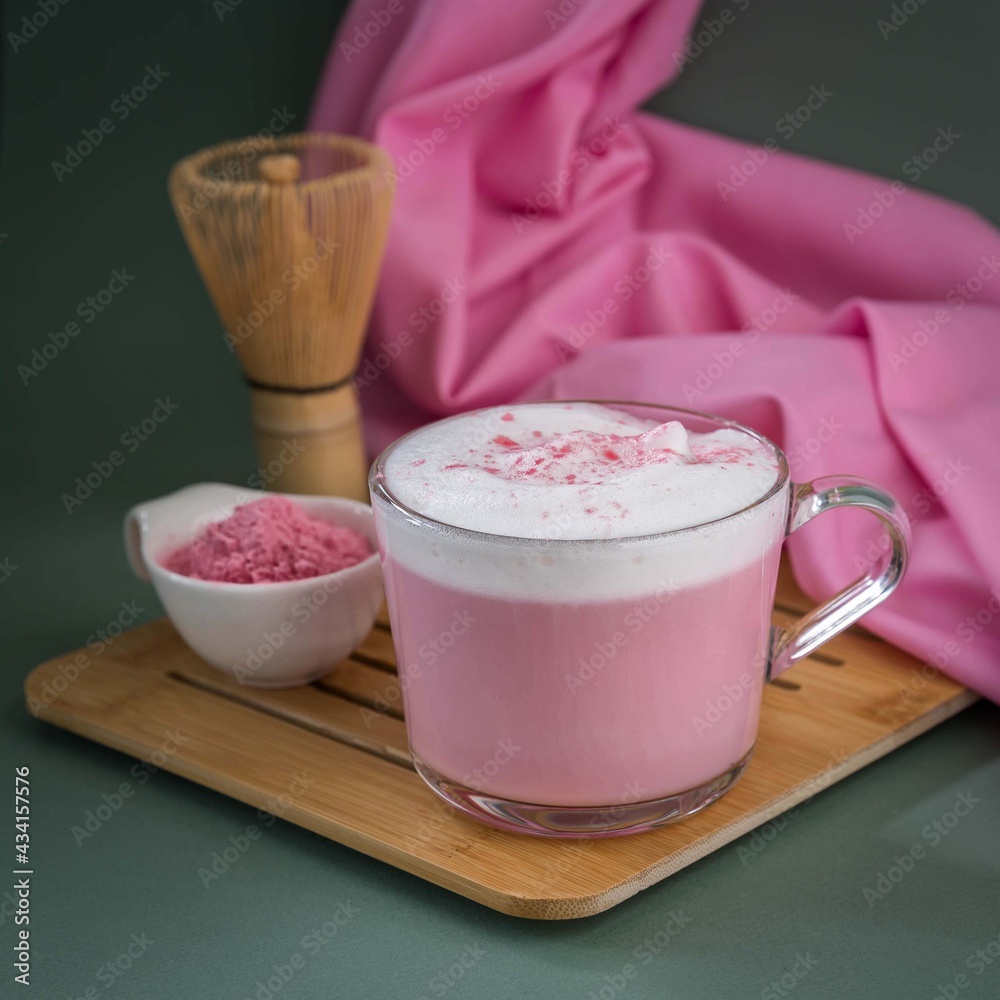 Cup of pink matcha latte drink on a pink napkin with a copy space ...