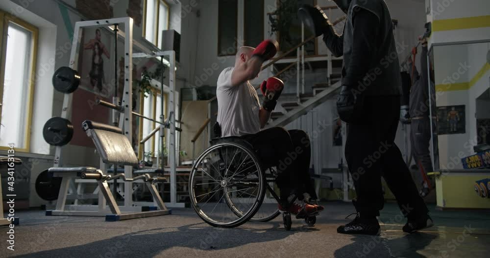 Training in the gym man smiling Paralympian with defective non ...
