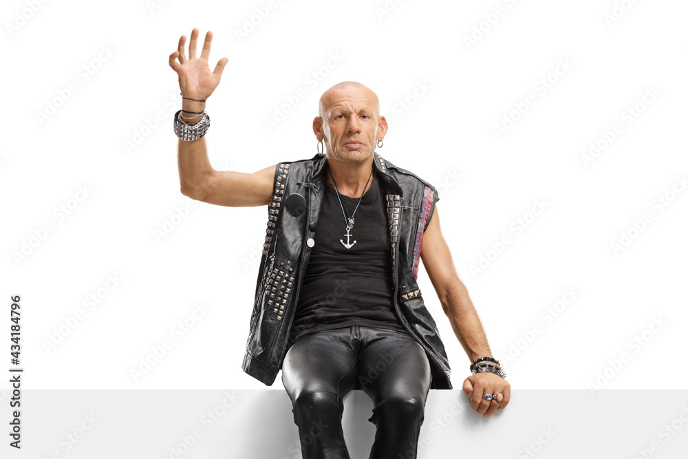 Bald man in leather clothes sitting on a panel and waving Stock Photo ...